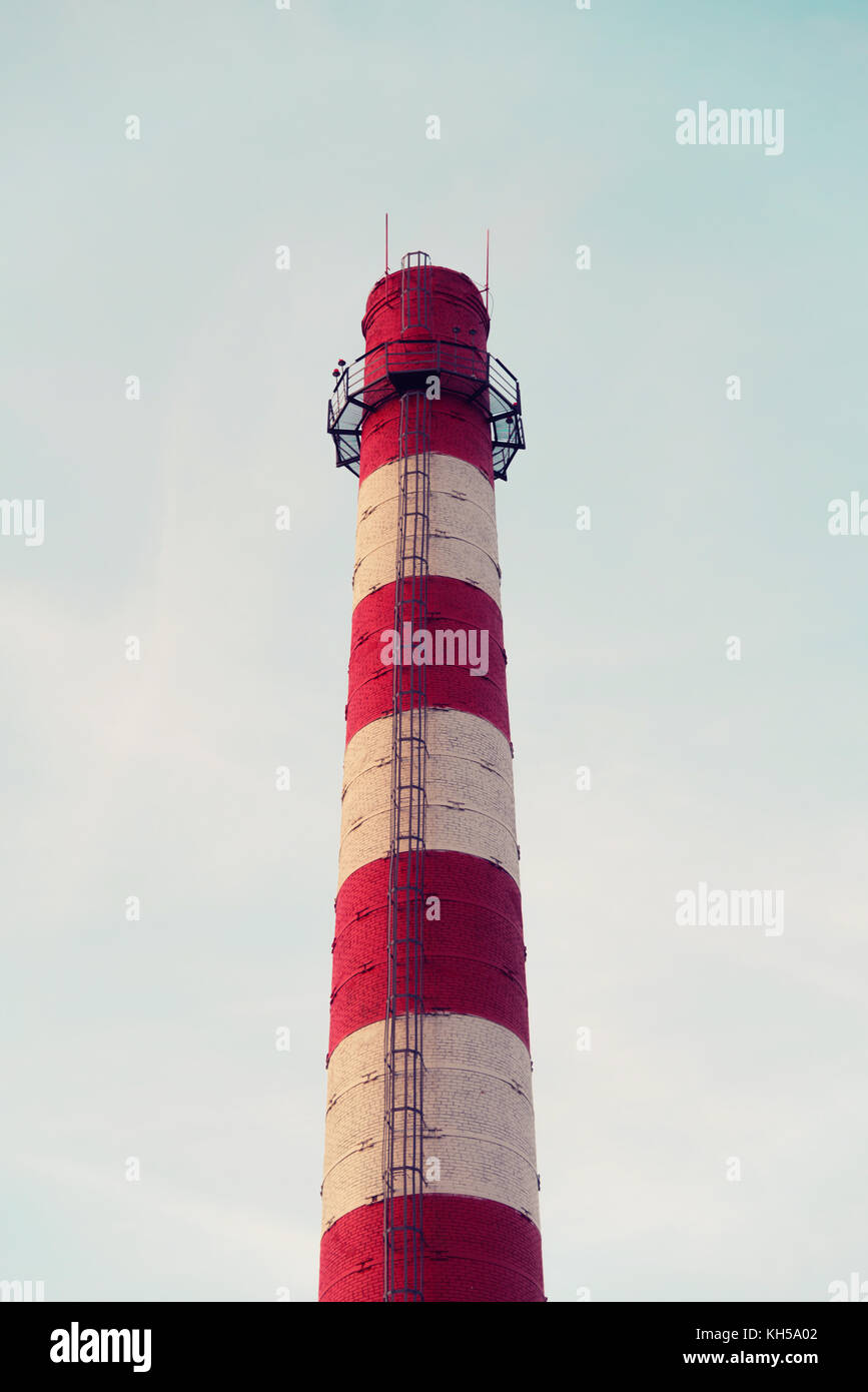 Red and white chimney on a blue sky background Stock Photo - Alamy