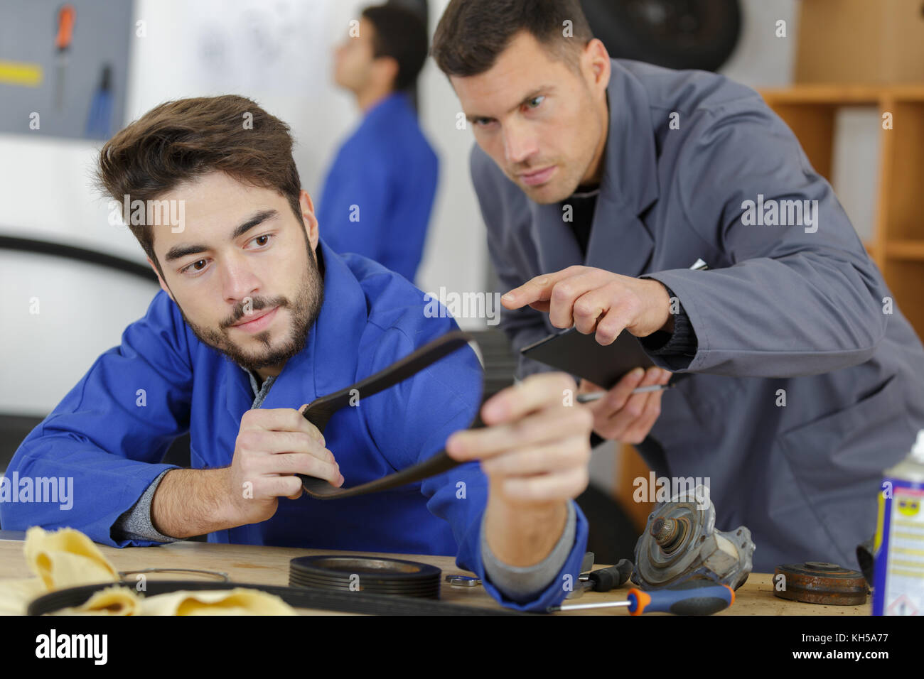two mechanics working on a car part Stock Photo - Alamy