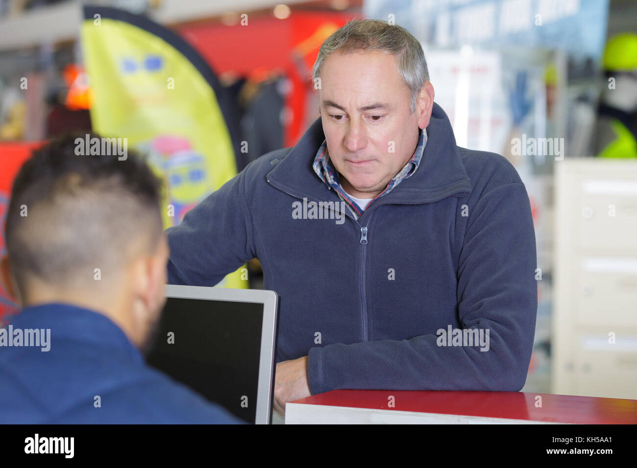 salesman and client at cash counter in hardware store Stock Photo - Alamy