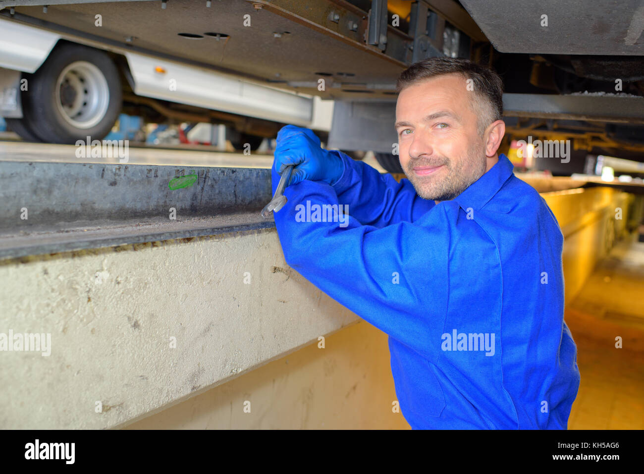 Mechanic working in pit Stock Photo - Alamy