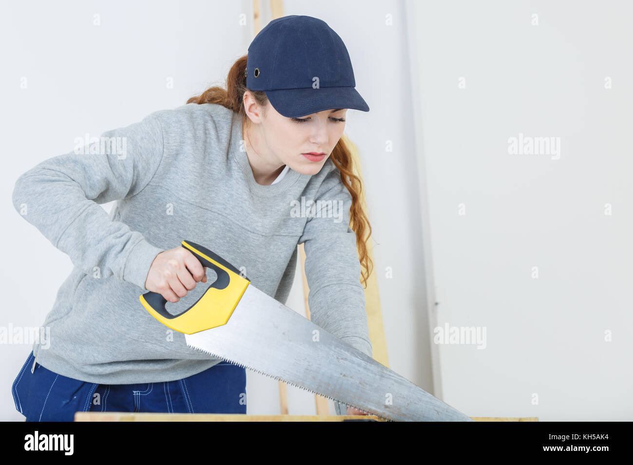 female carpenter using a manual saw Stock Photo - Alamy