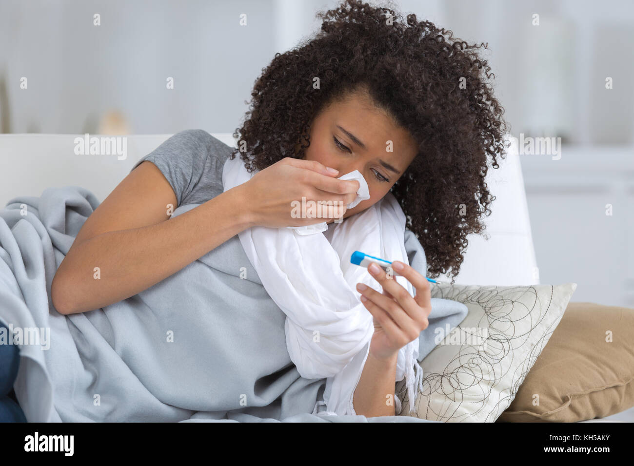 woman with temperature looking at thermometer Stock Photo - Alamy