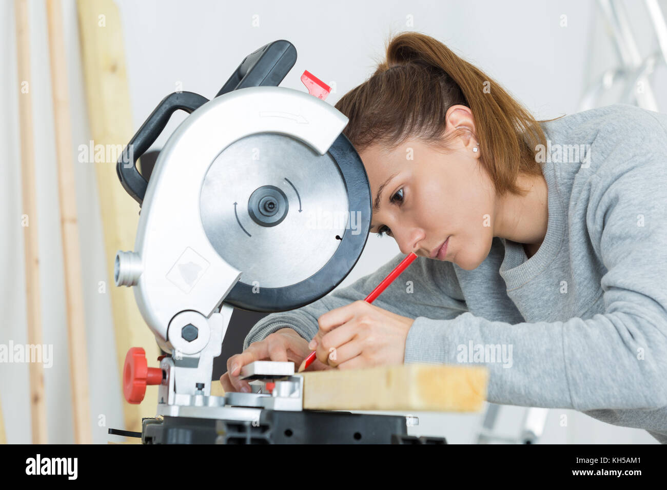 Worker marking position to cut wood with circular saw Stock Photo - Alamy