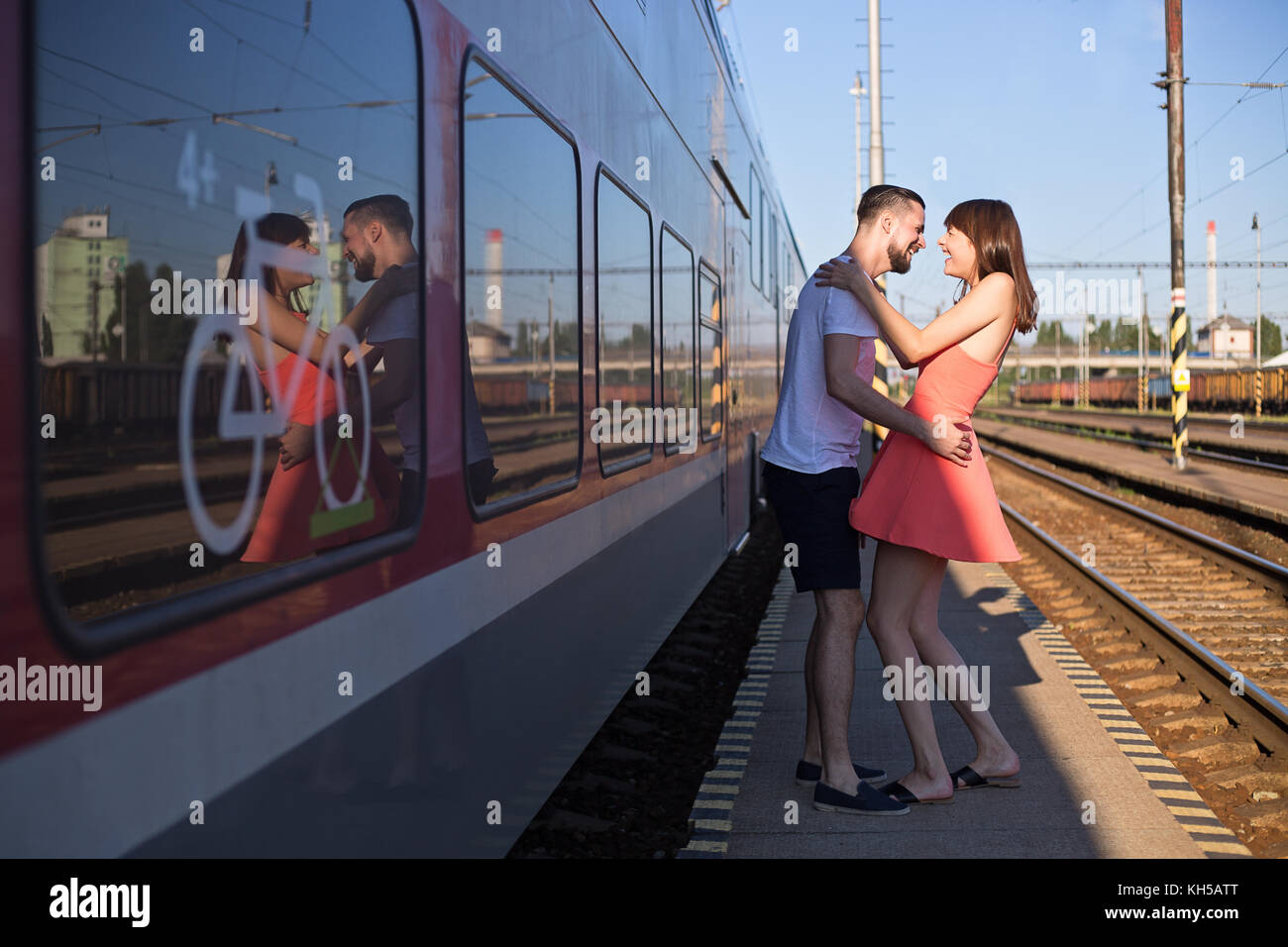 Happy laughing people at the train station standing next to the train ...