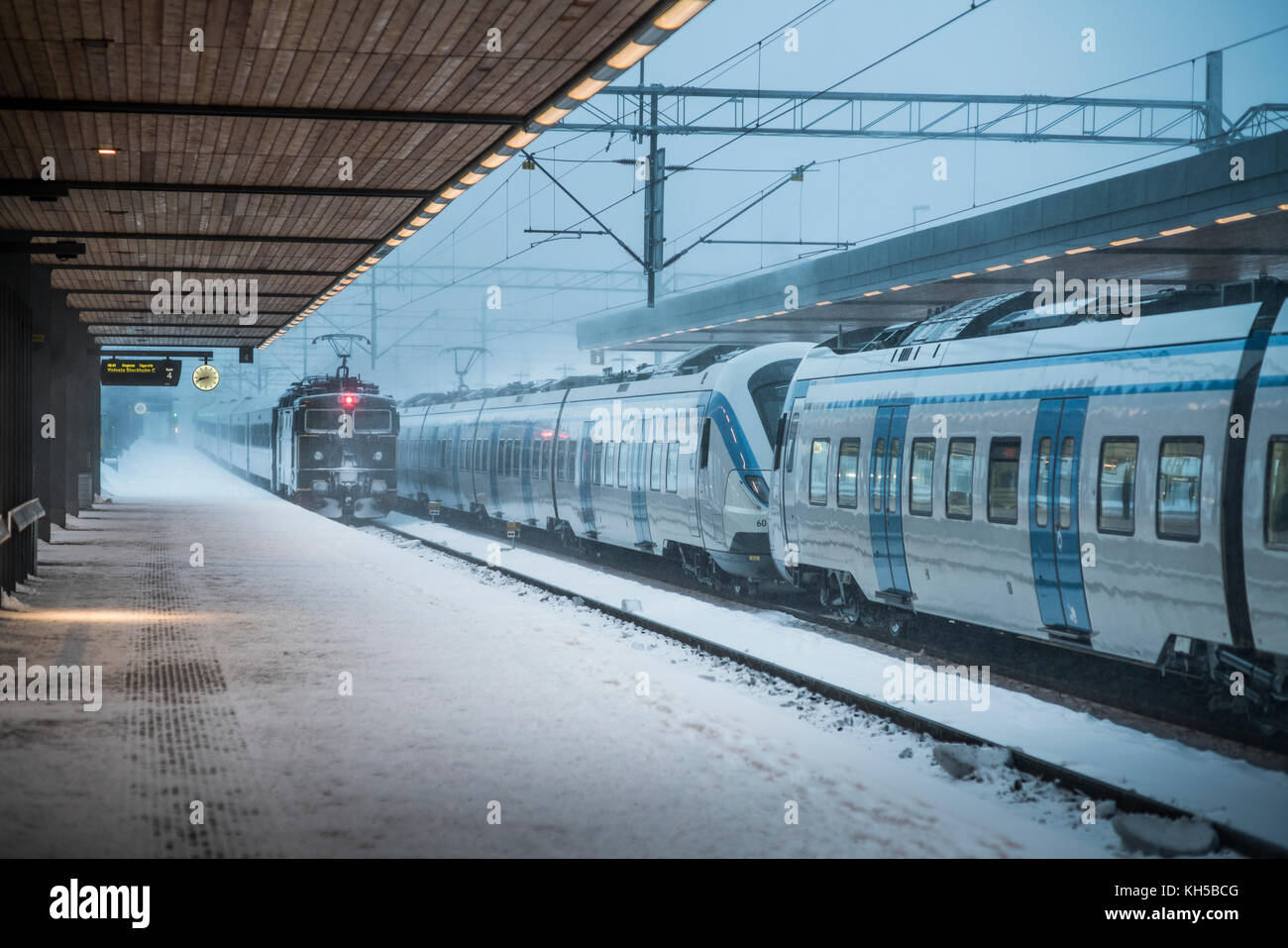 Winter blizzard, train arriving at railway station. Uppsala, Sweden ...