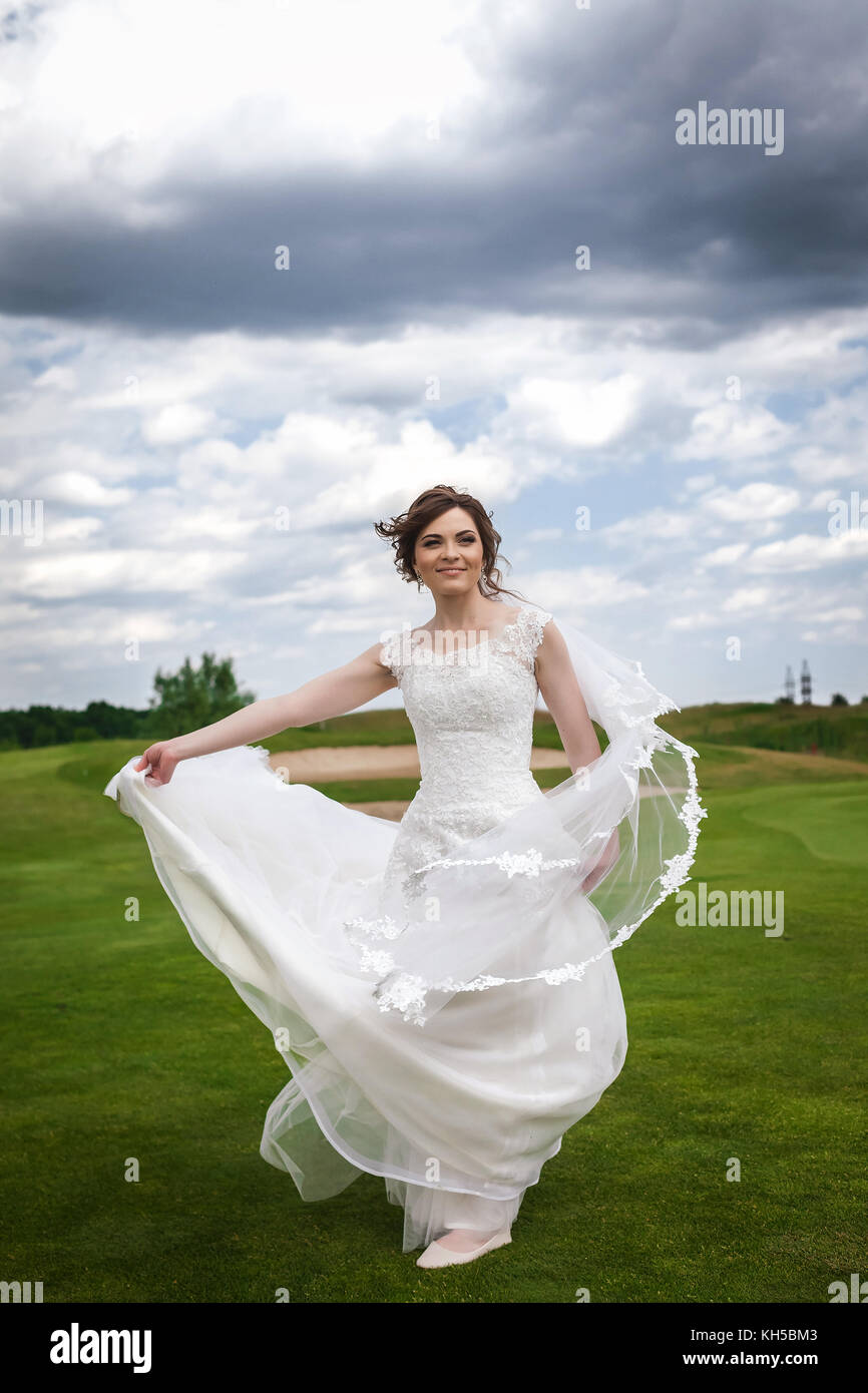 Attractive bride running on green golf course Stock Photo - Alamy
