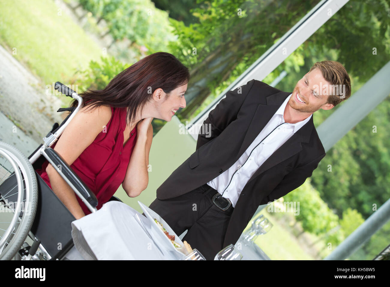 waiter serving disabled woman at the restaurant Stock Photo - Alamy