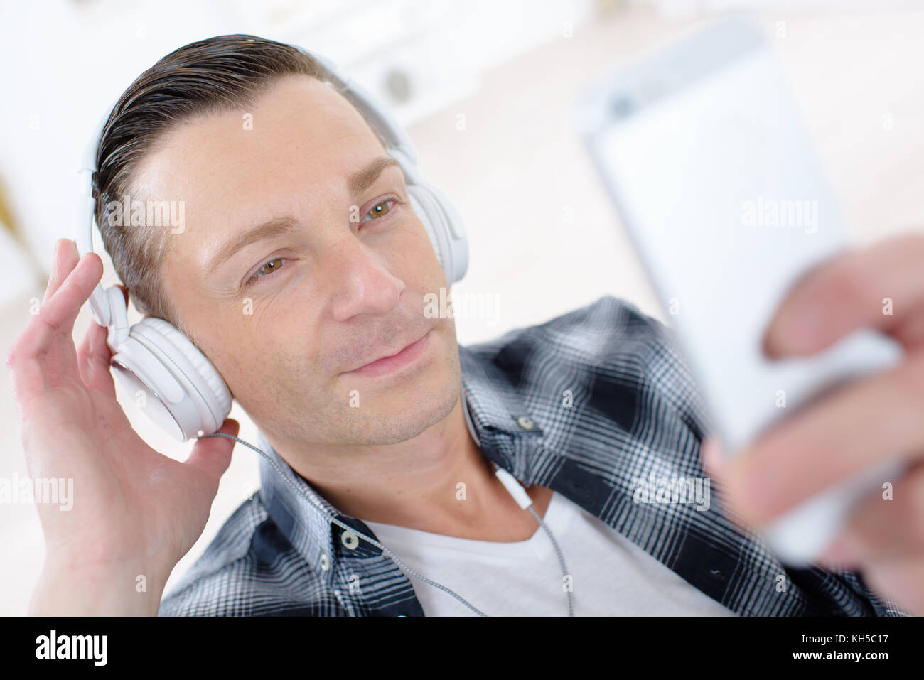 Boy watching his mobile phone with headset hi-res stock photography and ...