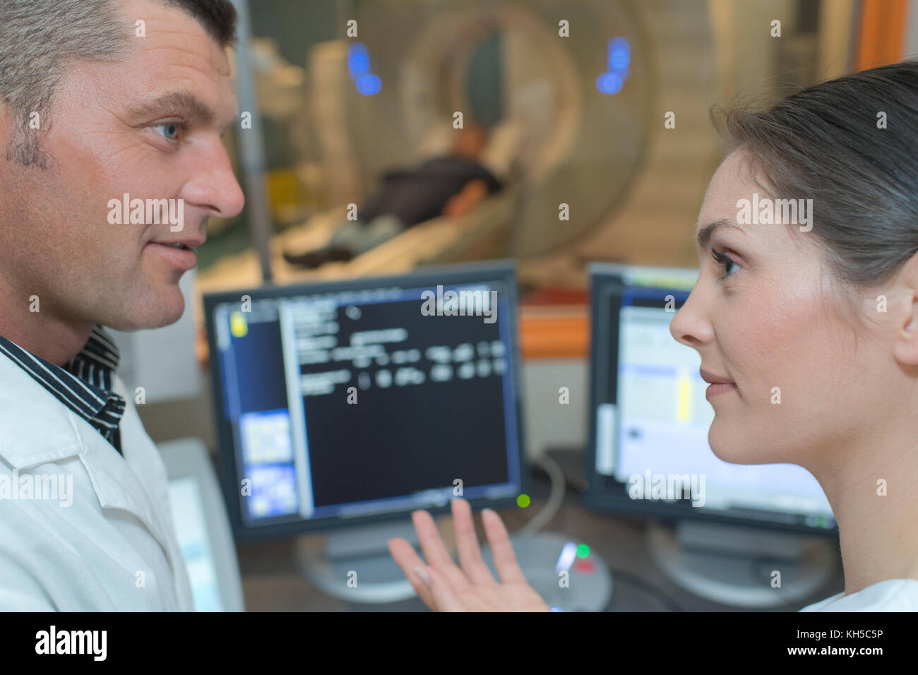 Male and female medics talking by computer Stock Photo - Alamy