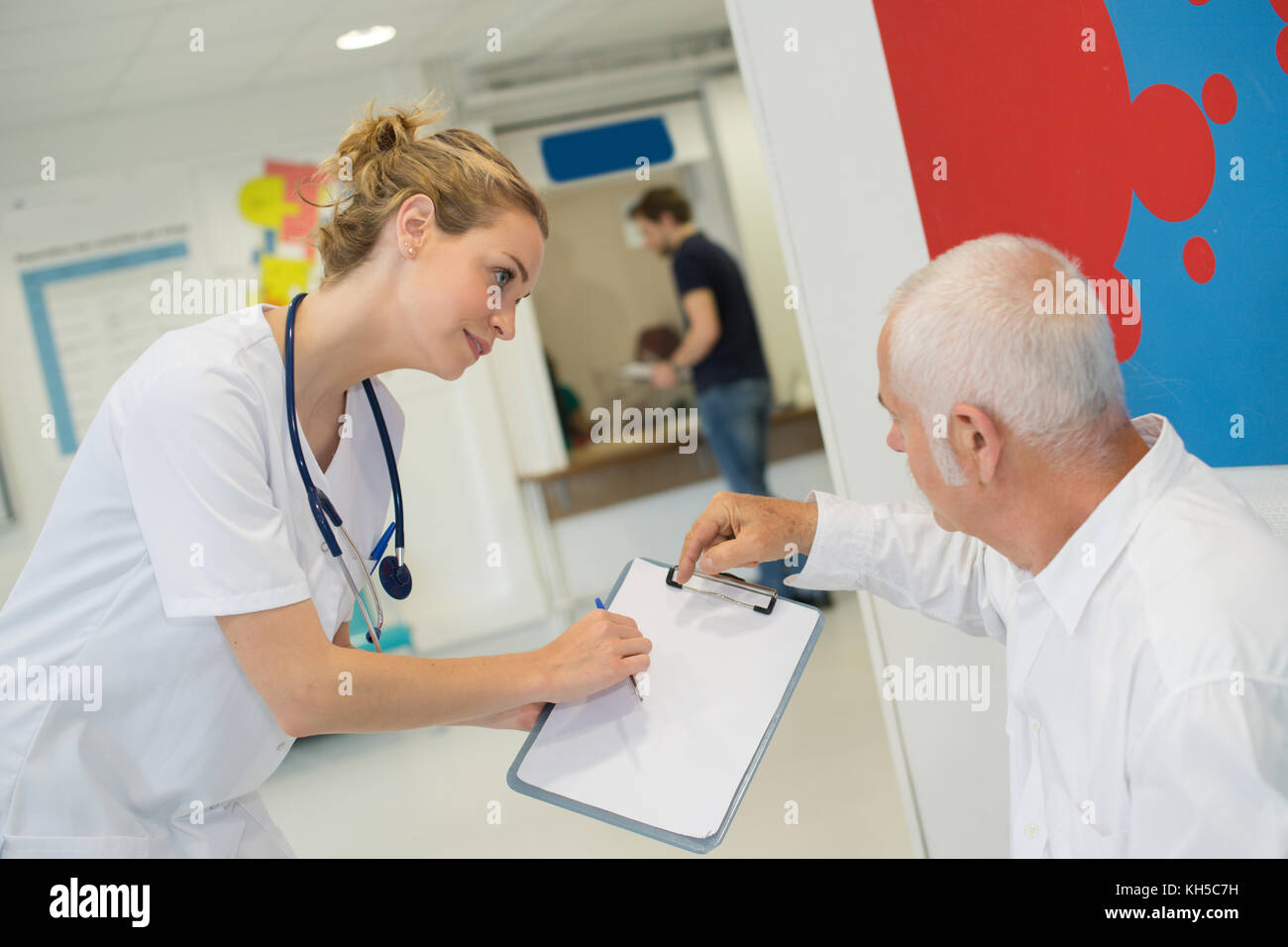 Medical worker showing paperwork to patient Stock Photo - Alamy