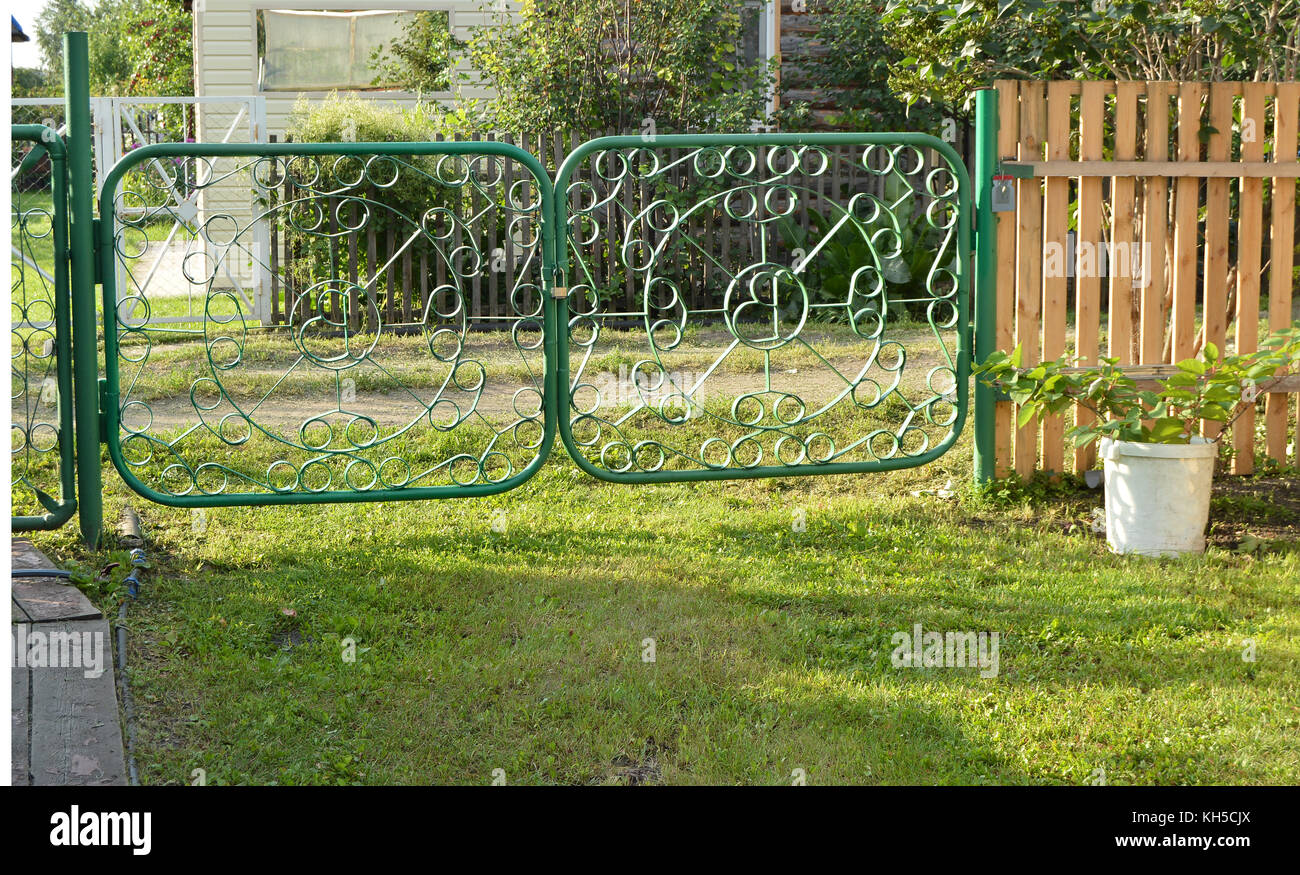 Green metal gate with a wicket - fence garden Stock Photo - Alamy