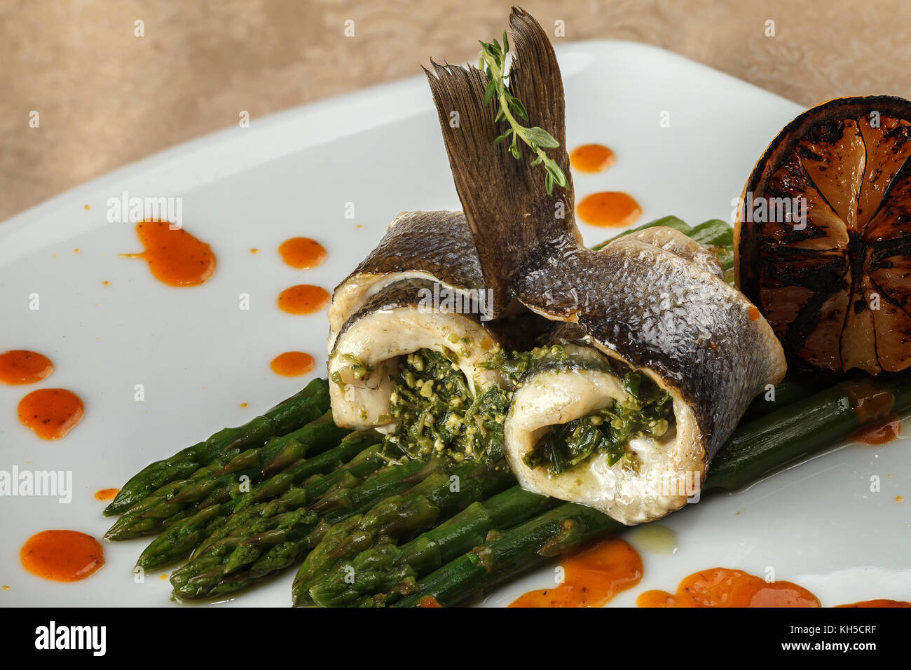 White fish rolls with asparagus and caramelized orange Stock Photo - Alamy