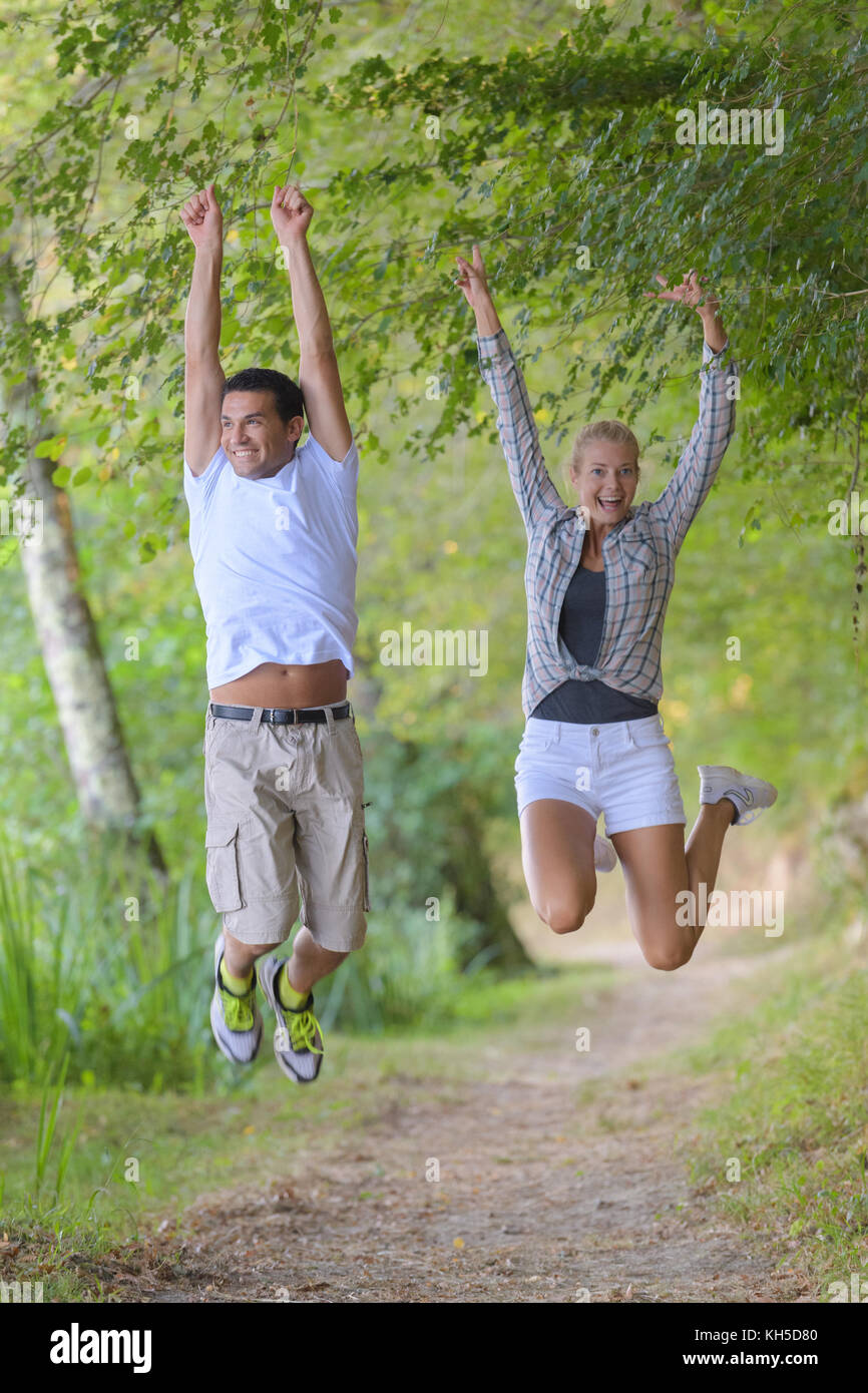 a couple jumping after completing their outdoor hike Stock Photo - Alamy