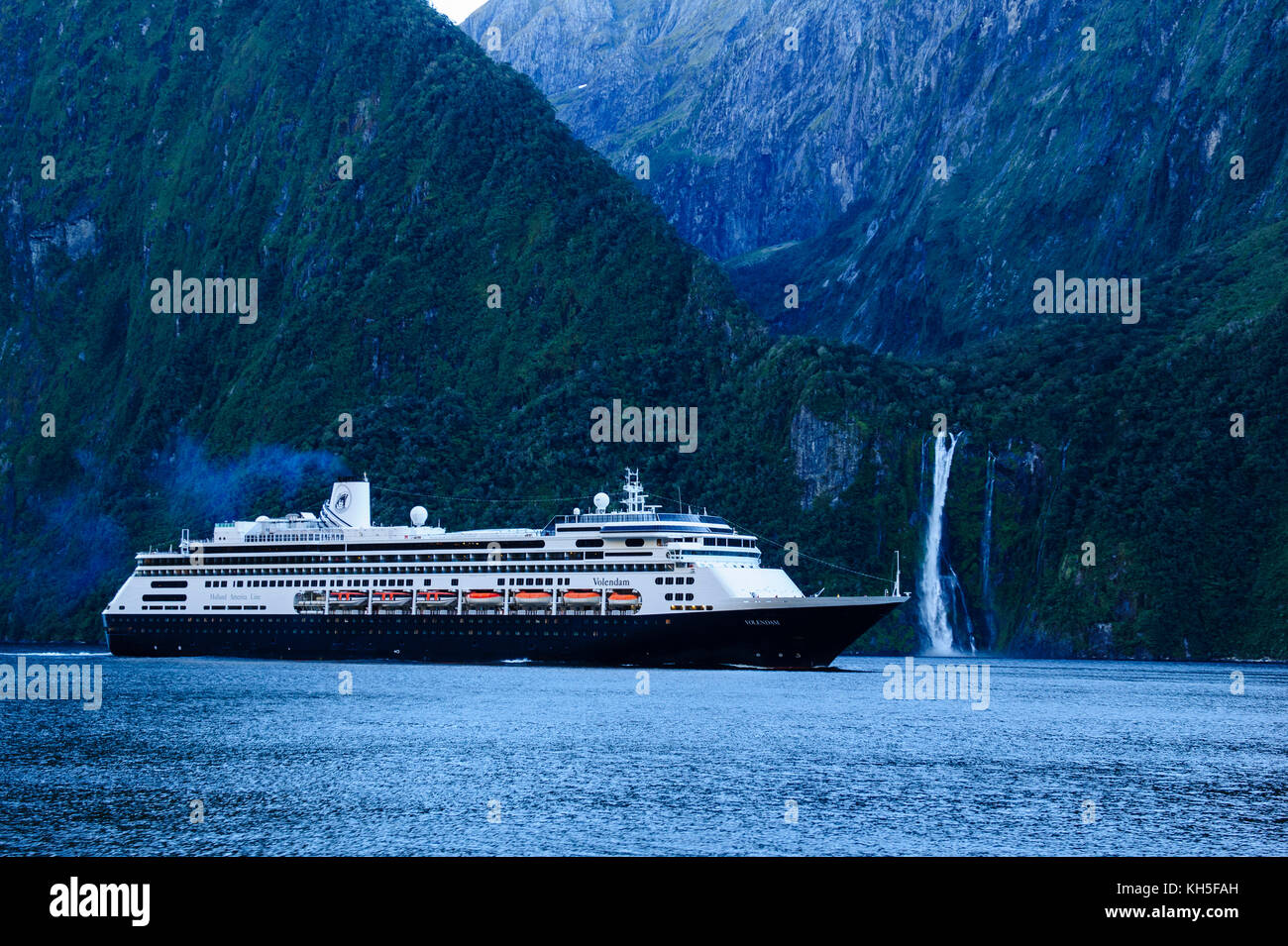 Cruise ship passing a waterfall in Milford Sound, South Island, New ...