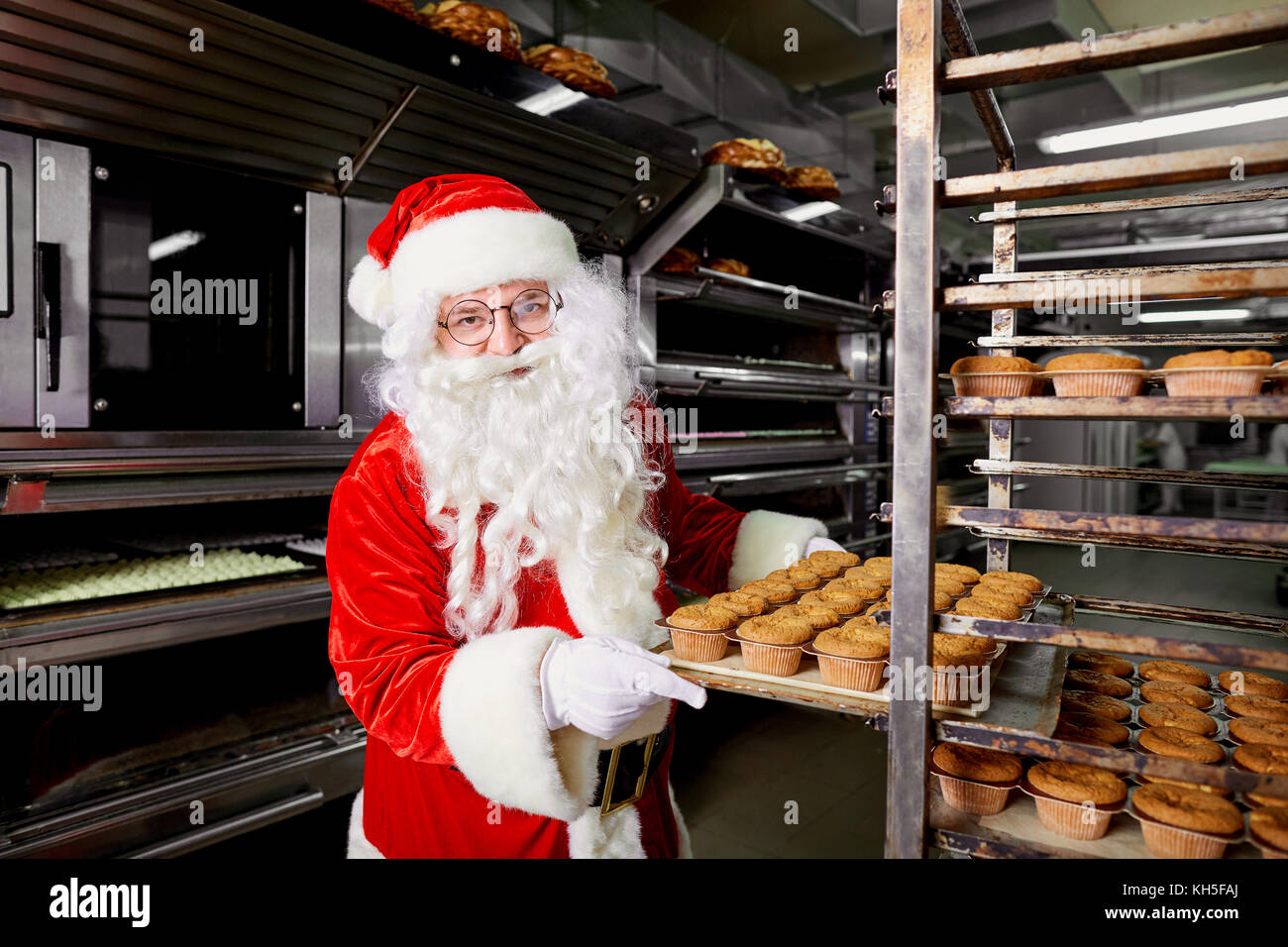 Santa Claus baker with a tray of cupcakes in his hands Christmas Stock ...