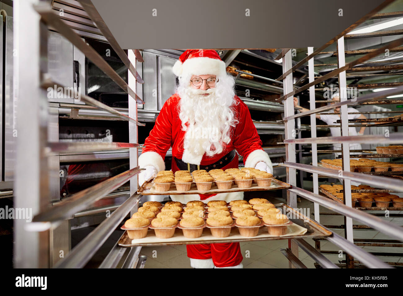 Santa Claus baker with a tray of cupcakes in his hands on Christ Stock ...