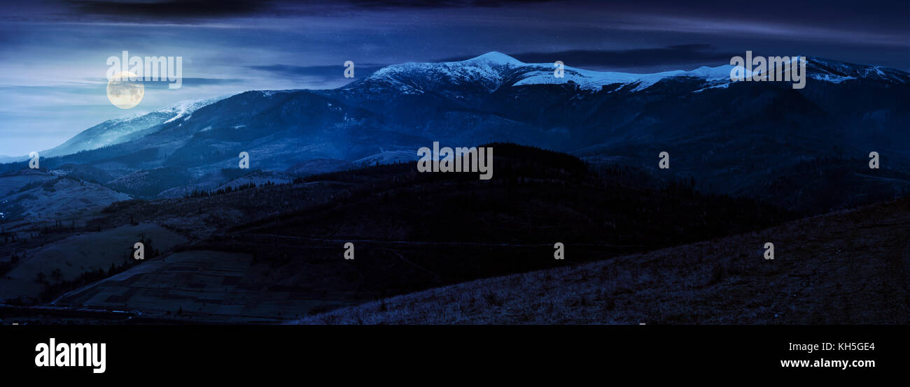 great mountain ridge Borzhava with snowy tops at night in full moon ...