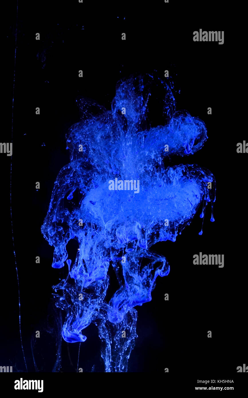 Blue dye in water creating a colourful abstract pattern isolated on a ...