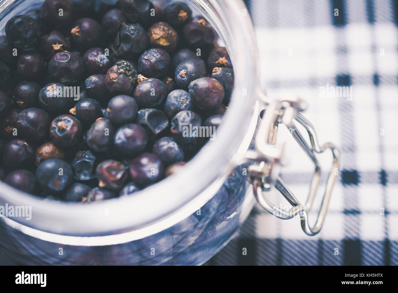Gin Ingredient: juniper berries in glass jar on blue and white tartan ...