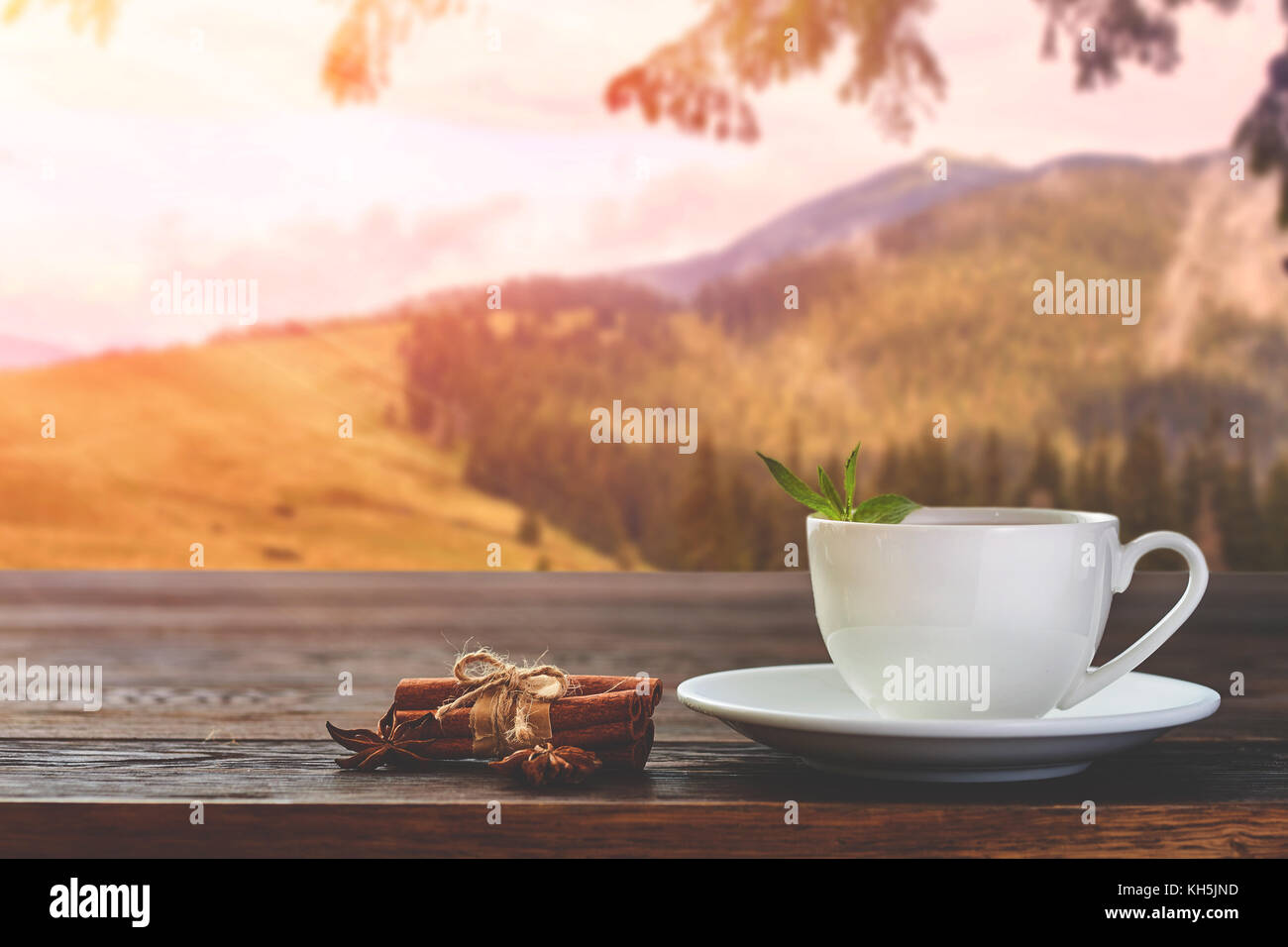 Cup with tea on table over mountains landscape with sunlight. Beauty ...