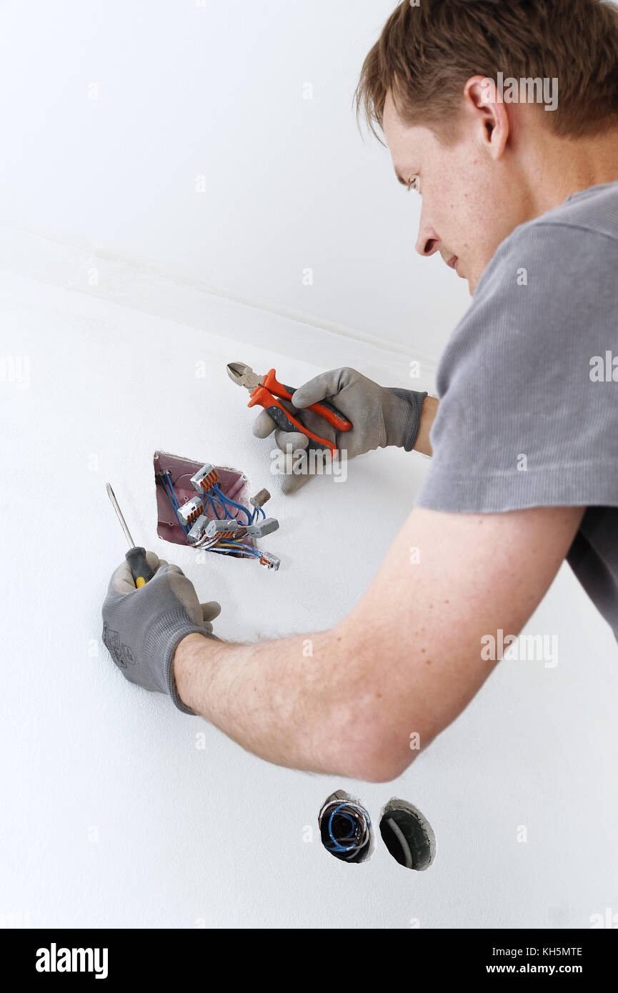 Electrician putting nuts on electrical wires in the box Stock Photo - Alamy