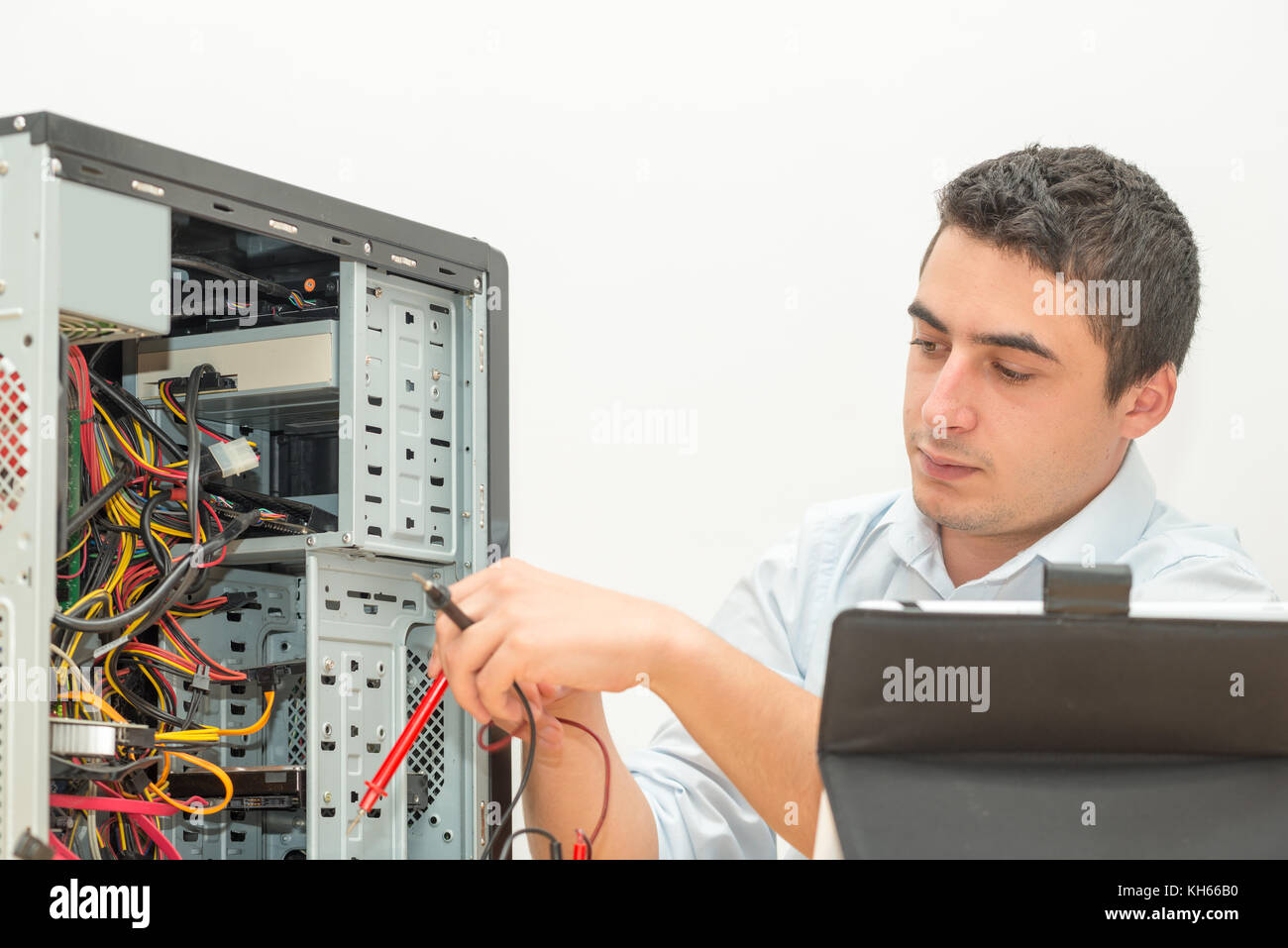 a young technician working on broken computer in his office Stock Photo ...