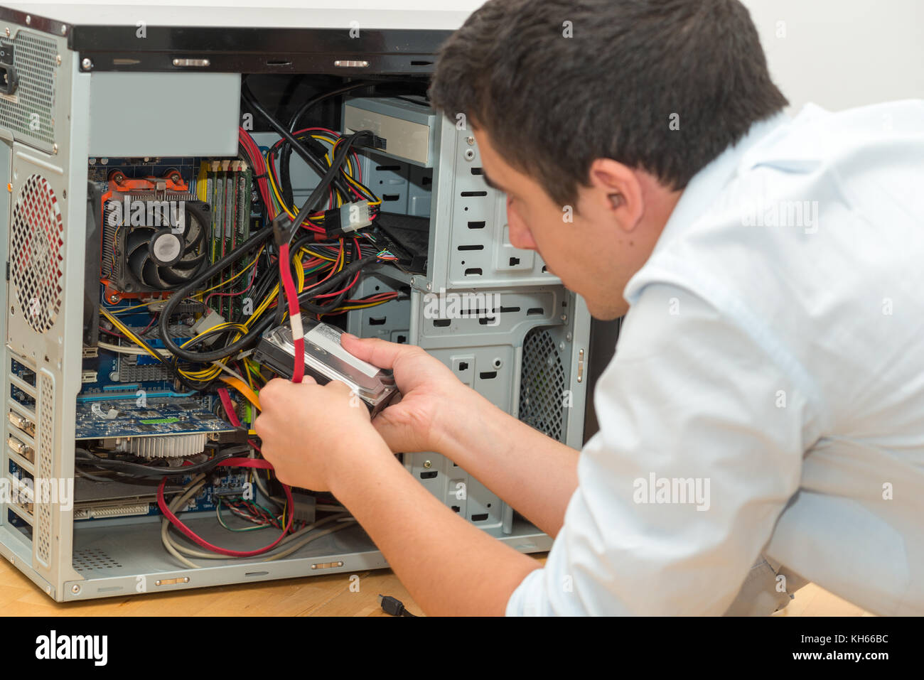 a young technician working on broken computer in his office Stock Photo ...