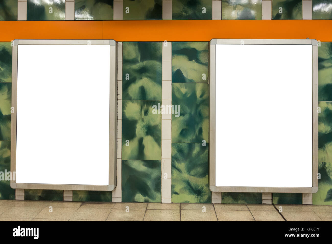 Two blank ad space signs on a wall in the underground from the front ...