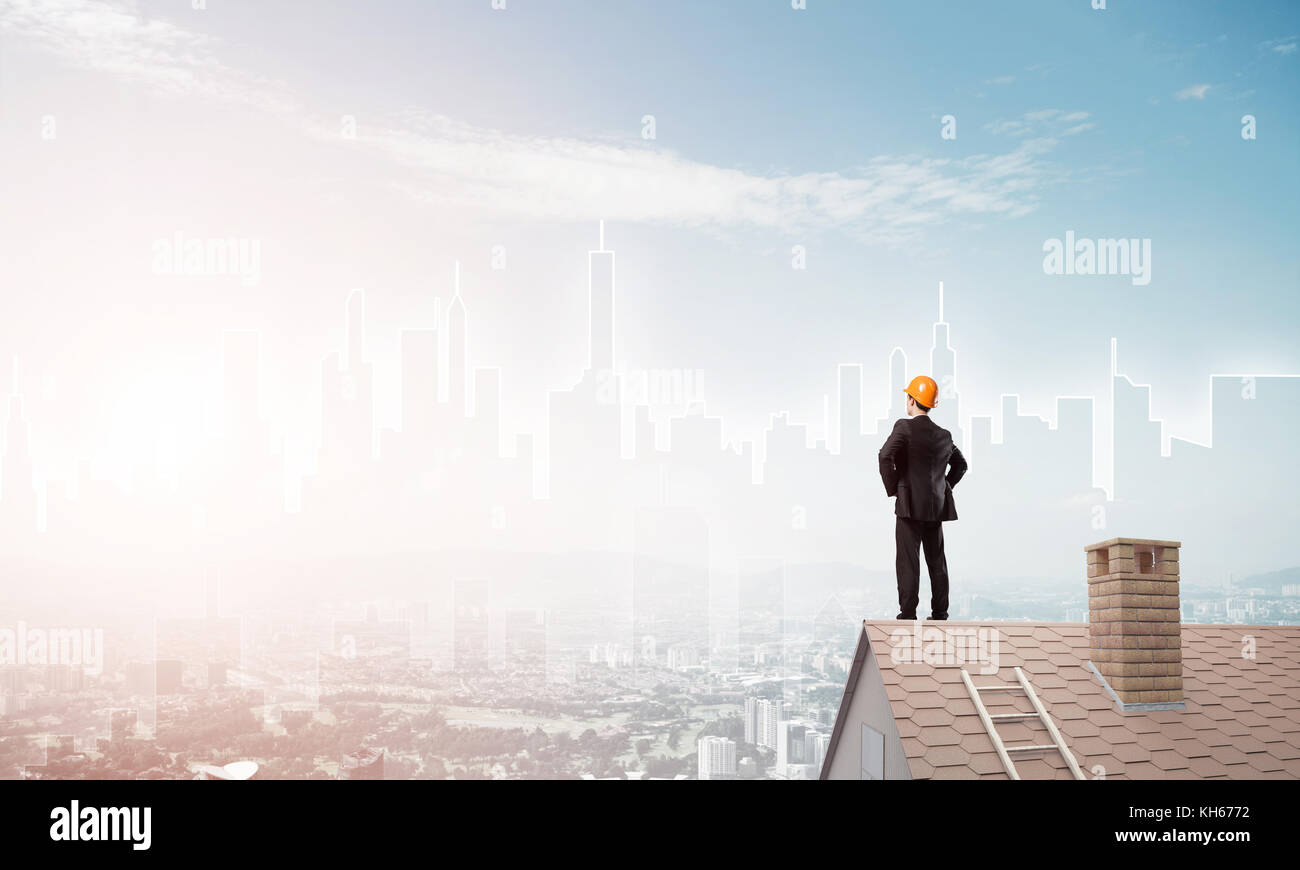 Engineer man standing on roof and looking away. Mixed media Stock Photo ...