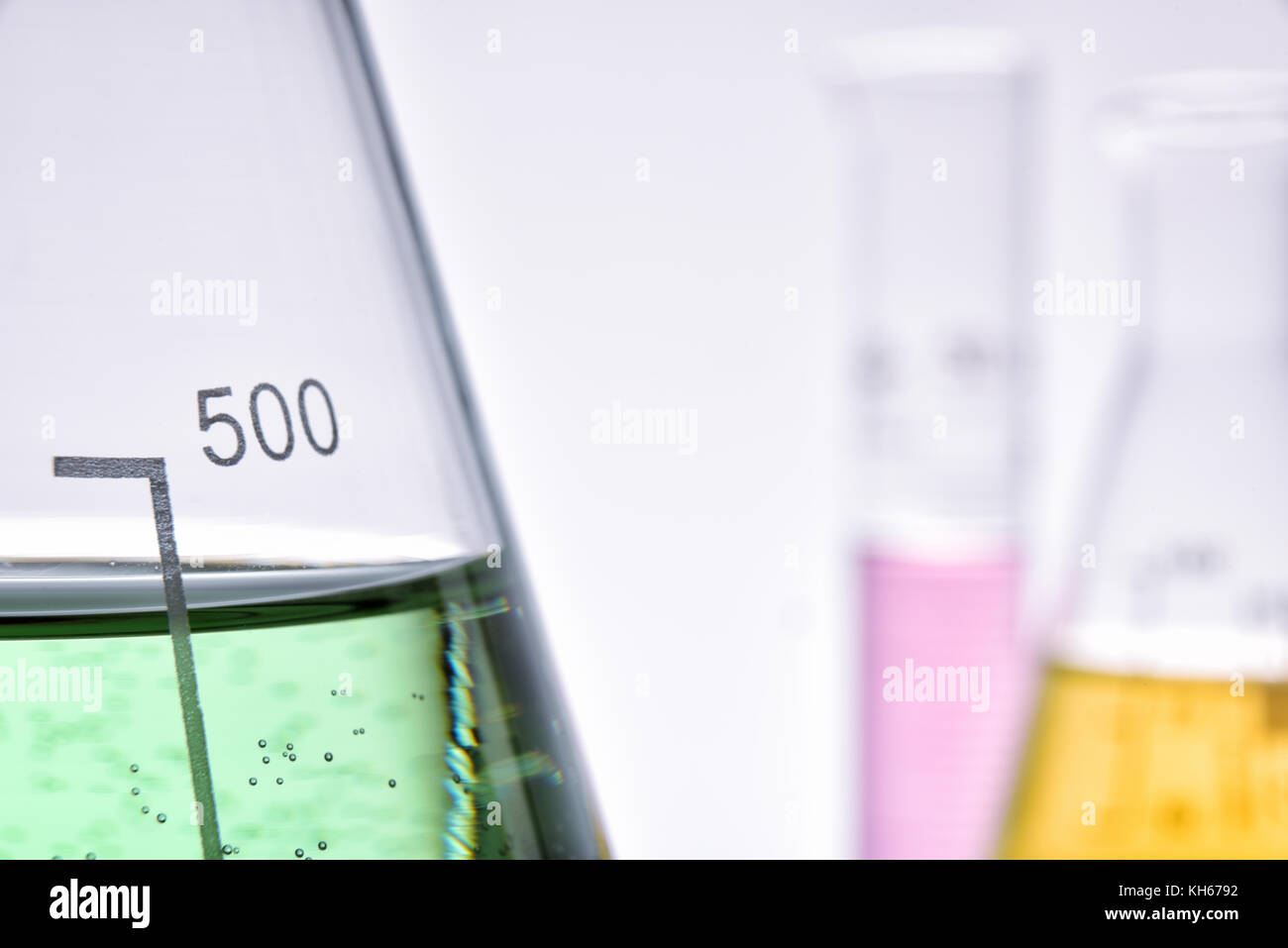 Laboratory glass chemical containers on glass table isolated colorful ...