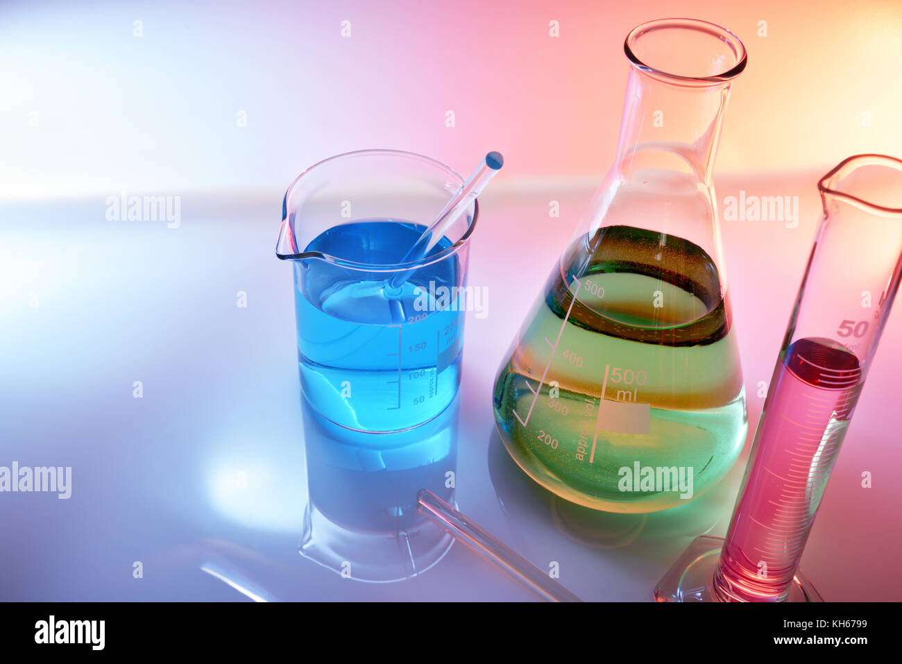 Laboratory glass chemical containers on glass table isolated colorful ...