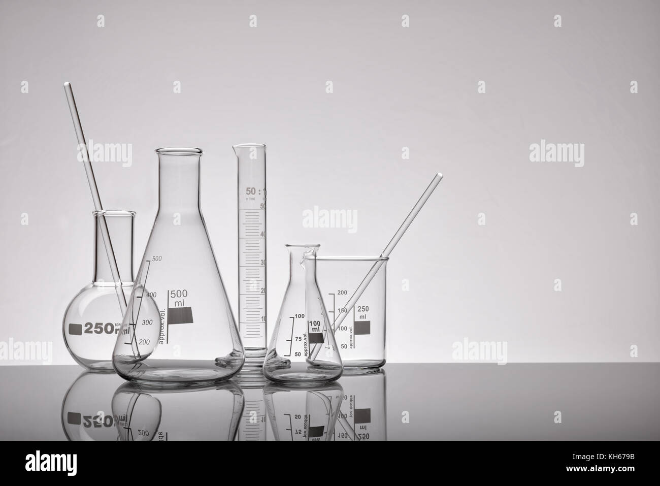 Supply of empty laboratory glass chemical containers on glass table ...