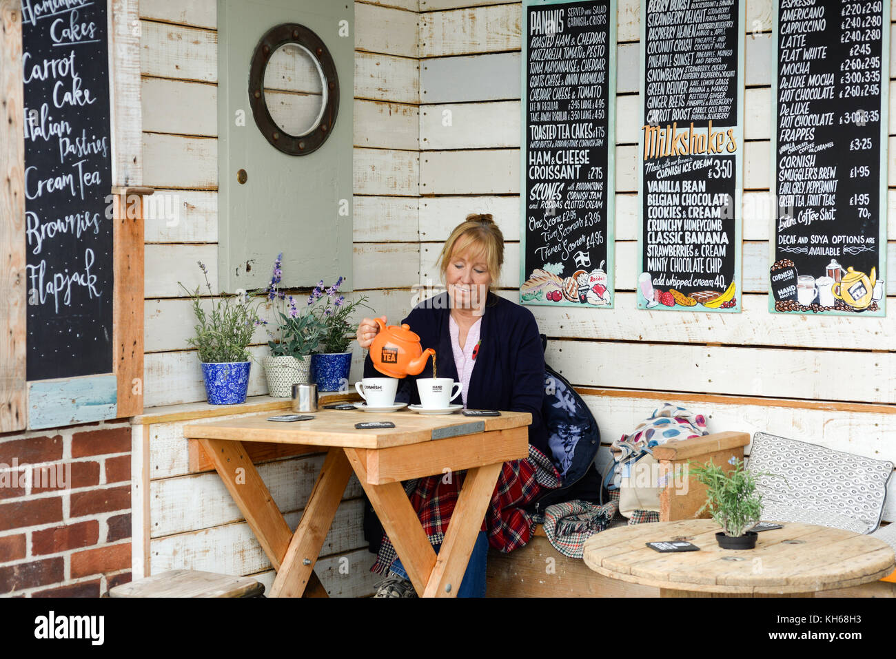 Woman pouring tea in a quaint cafe tea shop restaurant next to the ...