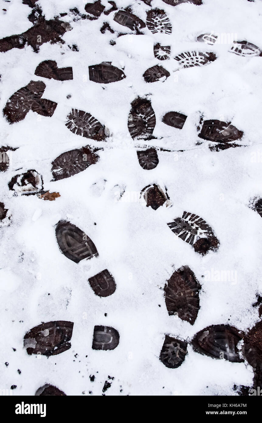Dirty footprints in the snow winter. Track from boots on the tra Stock ...