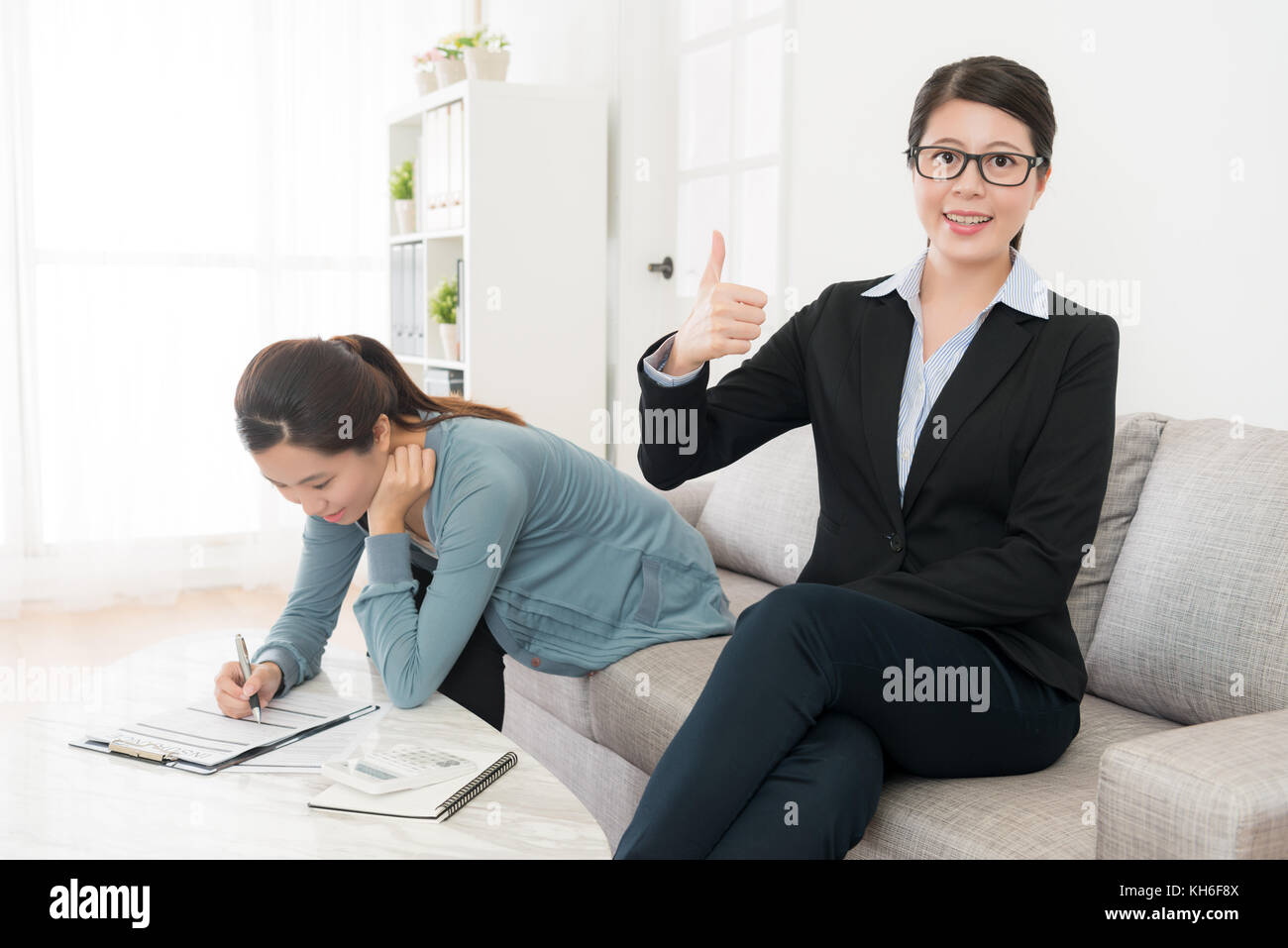young beautiful girl writing undersigned on insurance document at home ...