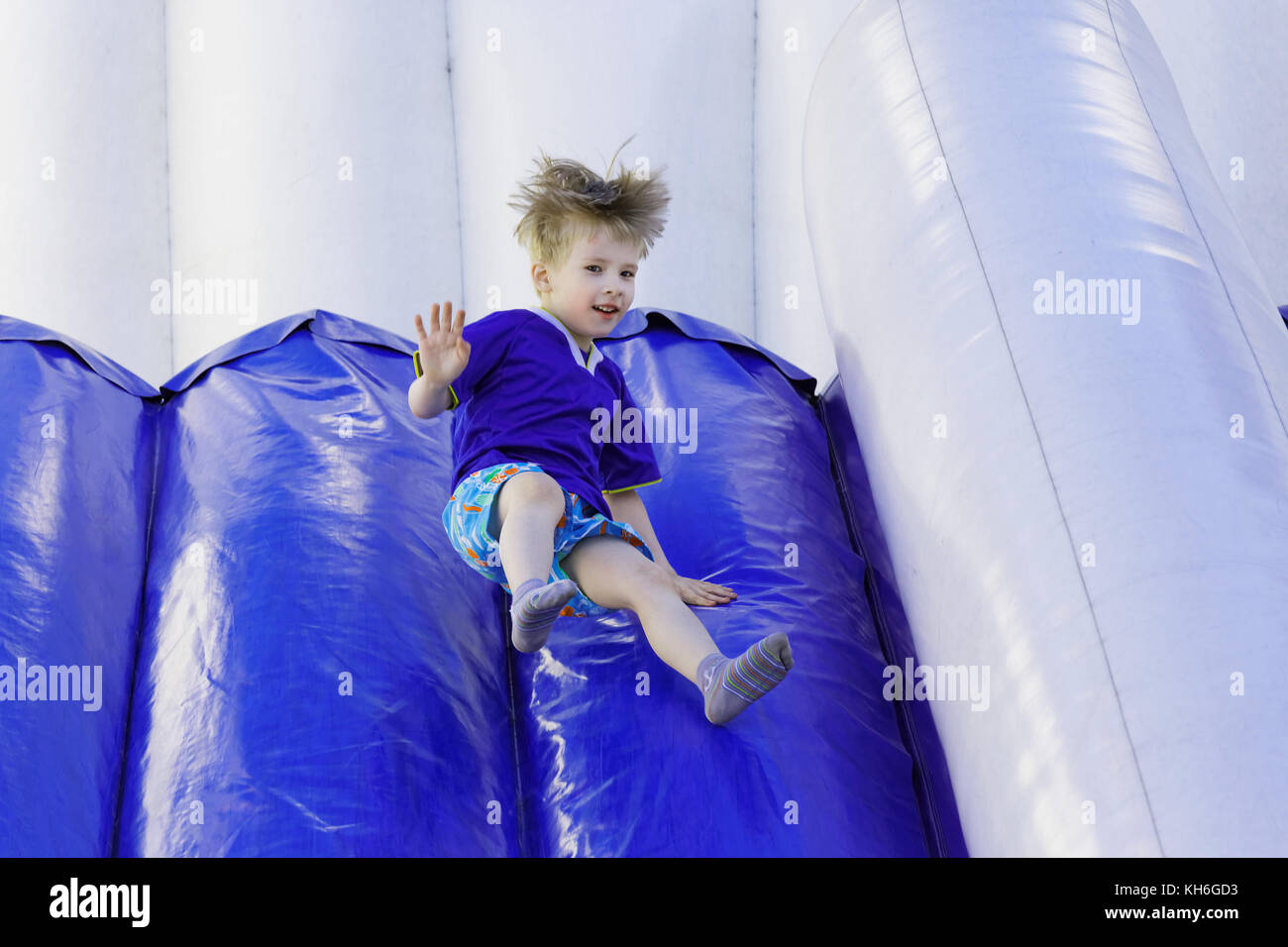 Boy slides down an inflatable slide in the amusement Park Stock Photo ...