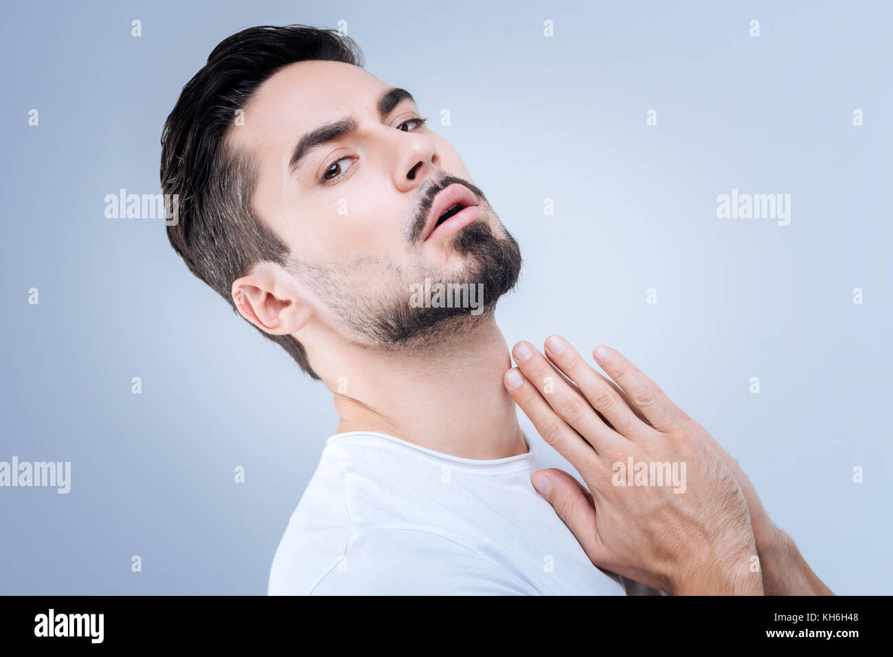 Emotional young man leaning back while looking straight Stock Photo - Alamy