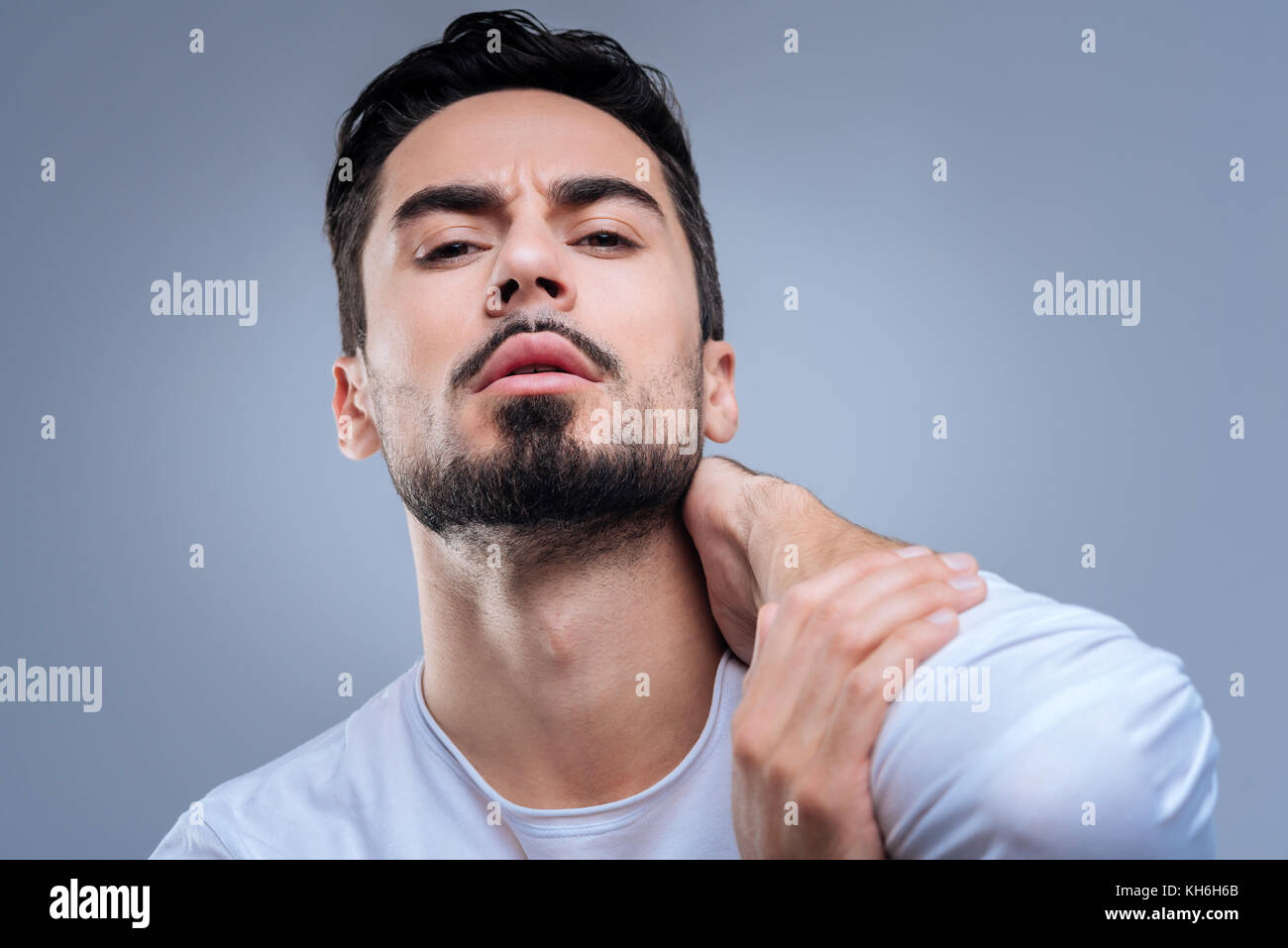 Unhappy serious man having a strange pain in his neck Stock Photo - Alamy