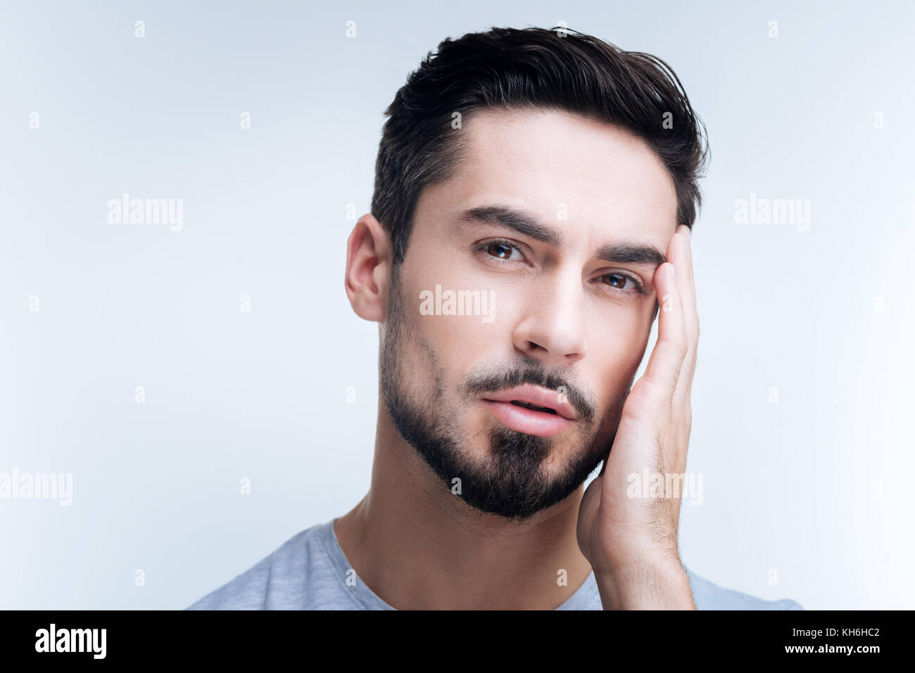 Tired man touching his head while having a headache Stock Photo - Alamy