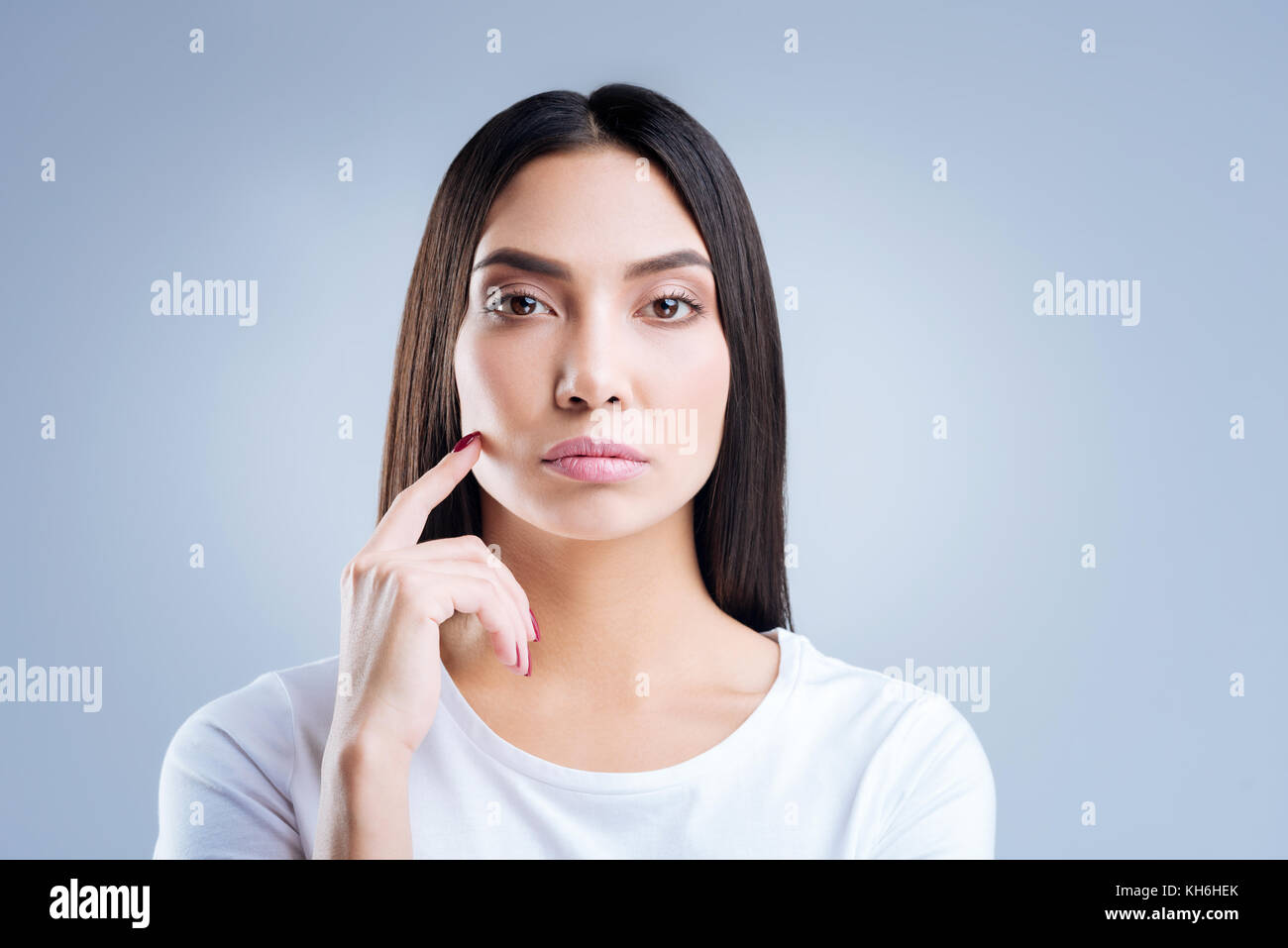Beautiful clever employer looking strict while listening to her ...