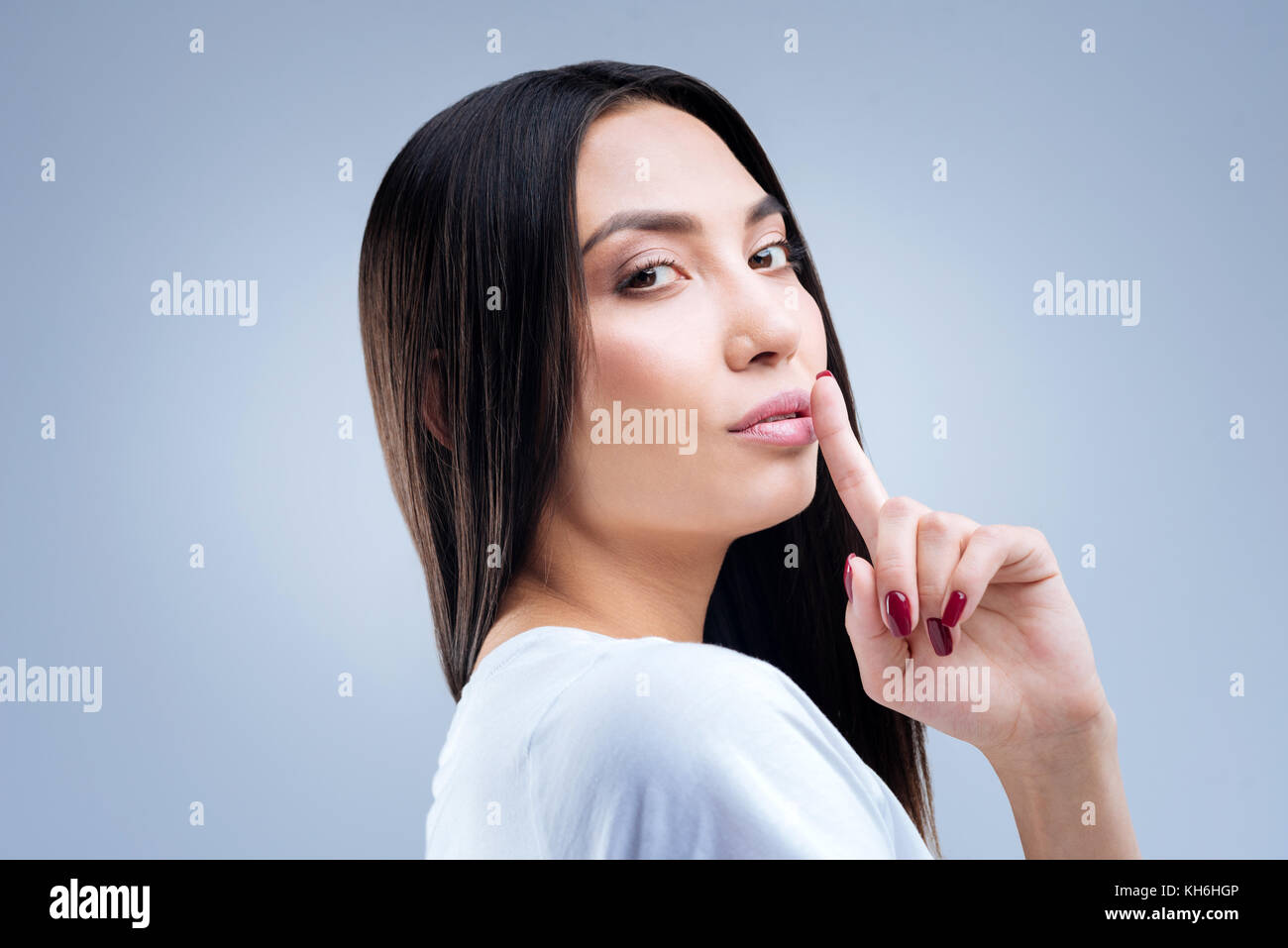 Adorable young woman pressing her finger to the lips Stock Photo - Alamy
