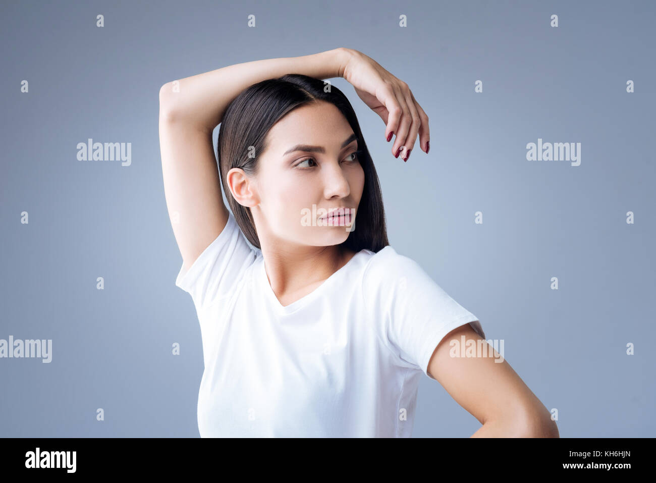 Beautiful young woman standing with her arm resting on the head Stock ...