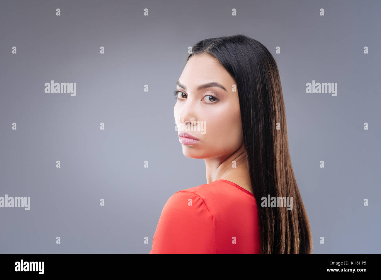 Sad young woman feeling unhappy while standing alone in a room Stock ...