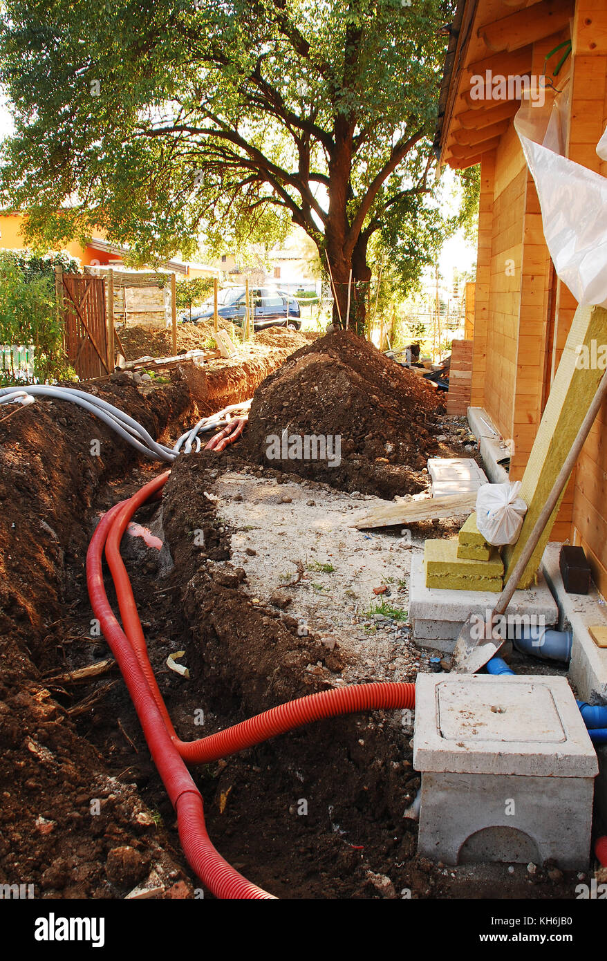 A utilities trench at the side of a newly build wood (fir) house. The ...