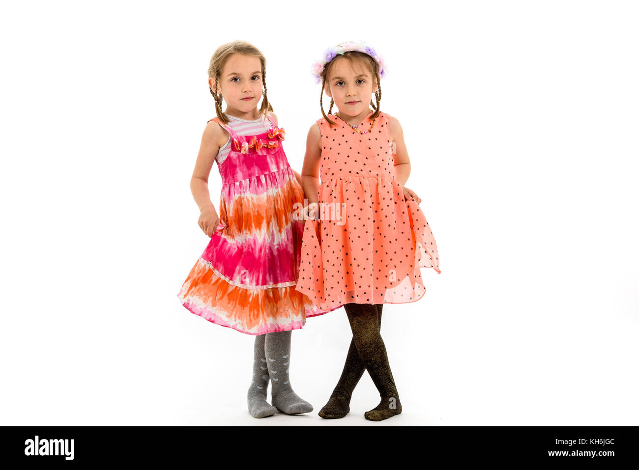 Identical twin girls sisters are posing for the camera. Happy twin ...