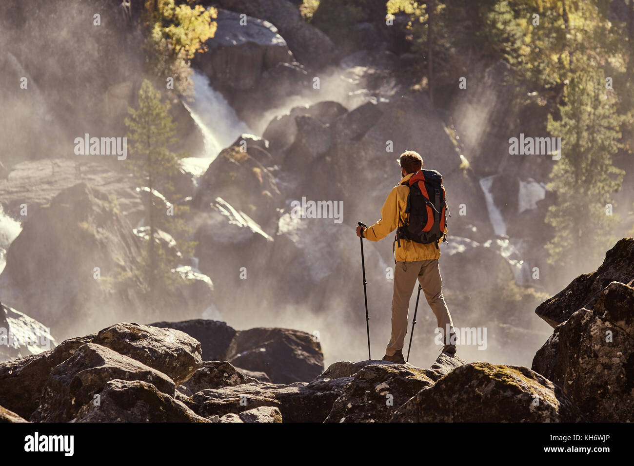 Hiker hiking with backpack looking at waterfall in park in beautiful ...