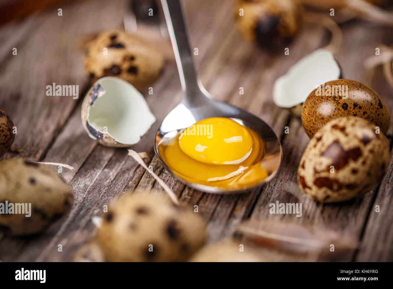 Unboiled quail eggs in spoon on wooden background Stock Photo - Alamy