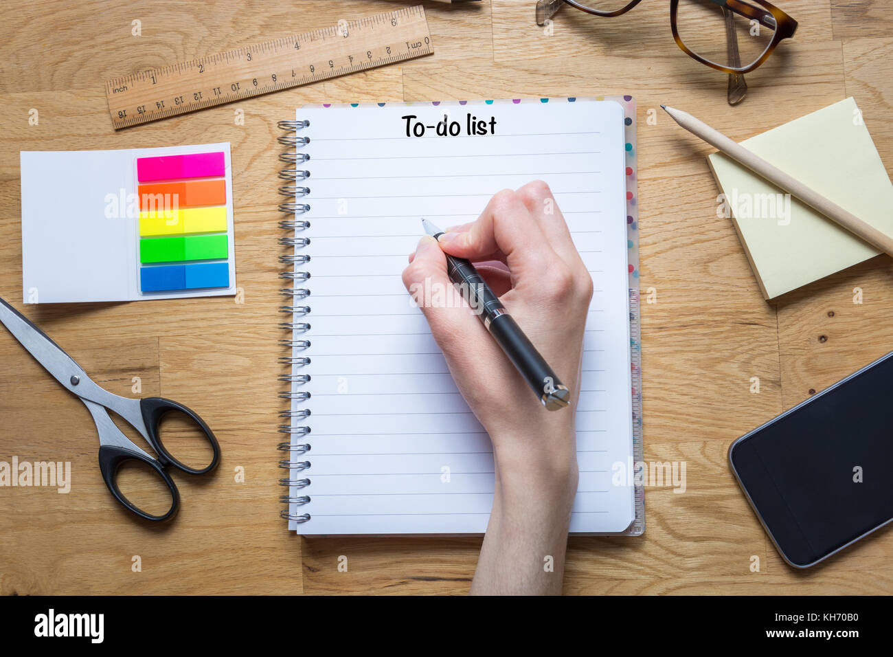 Writing on notepad with to-do list and pen and other accessories on a ...