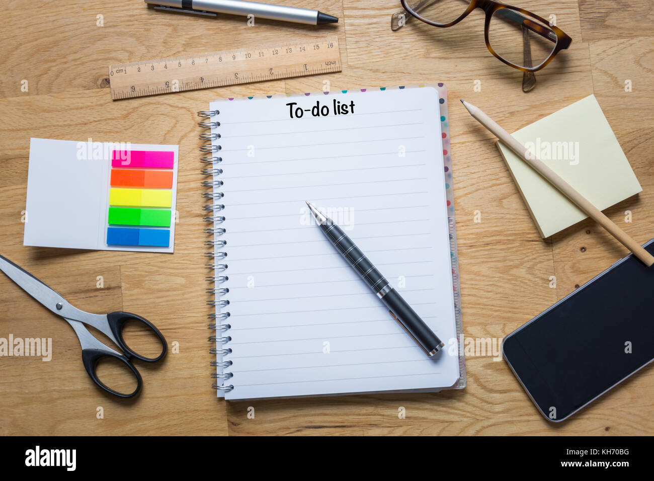 A notepad with To-do list at the top and pen and other accessories on a ...