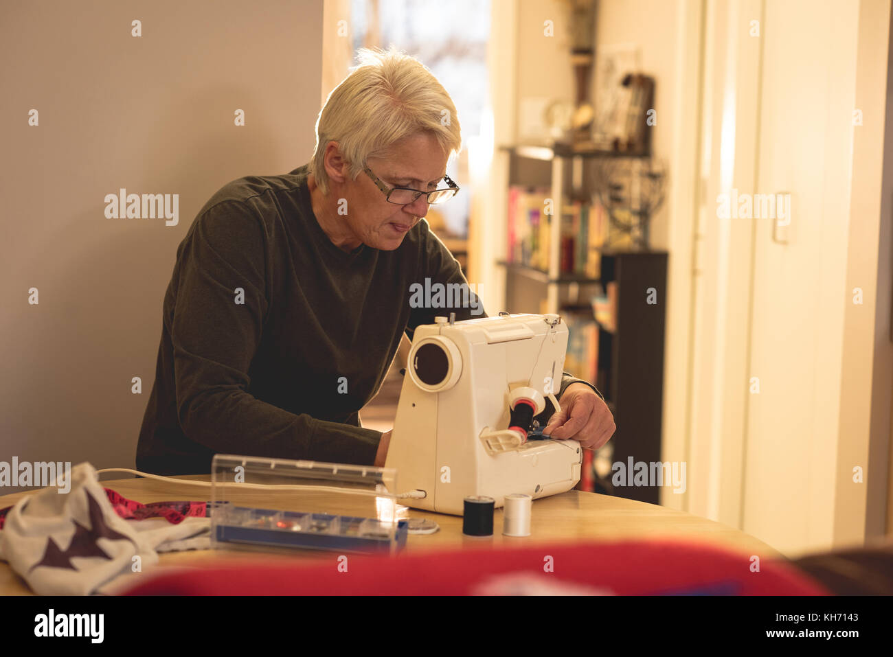 Senior woman using a sewing machine at home Stock Photo - Alamy